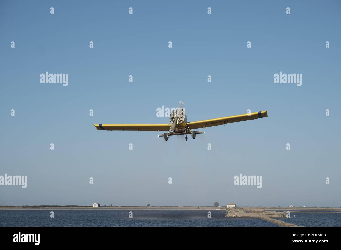 A single-engine propeller airplane flying in a perfectly clear blue sky ...