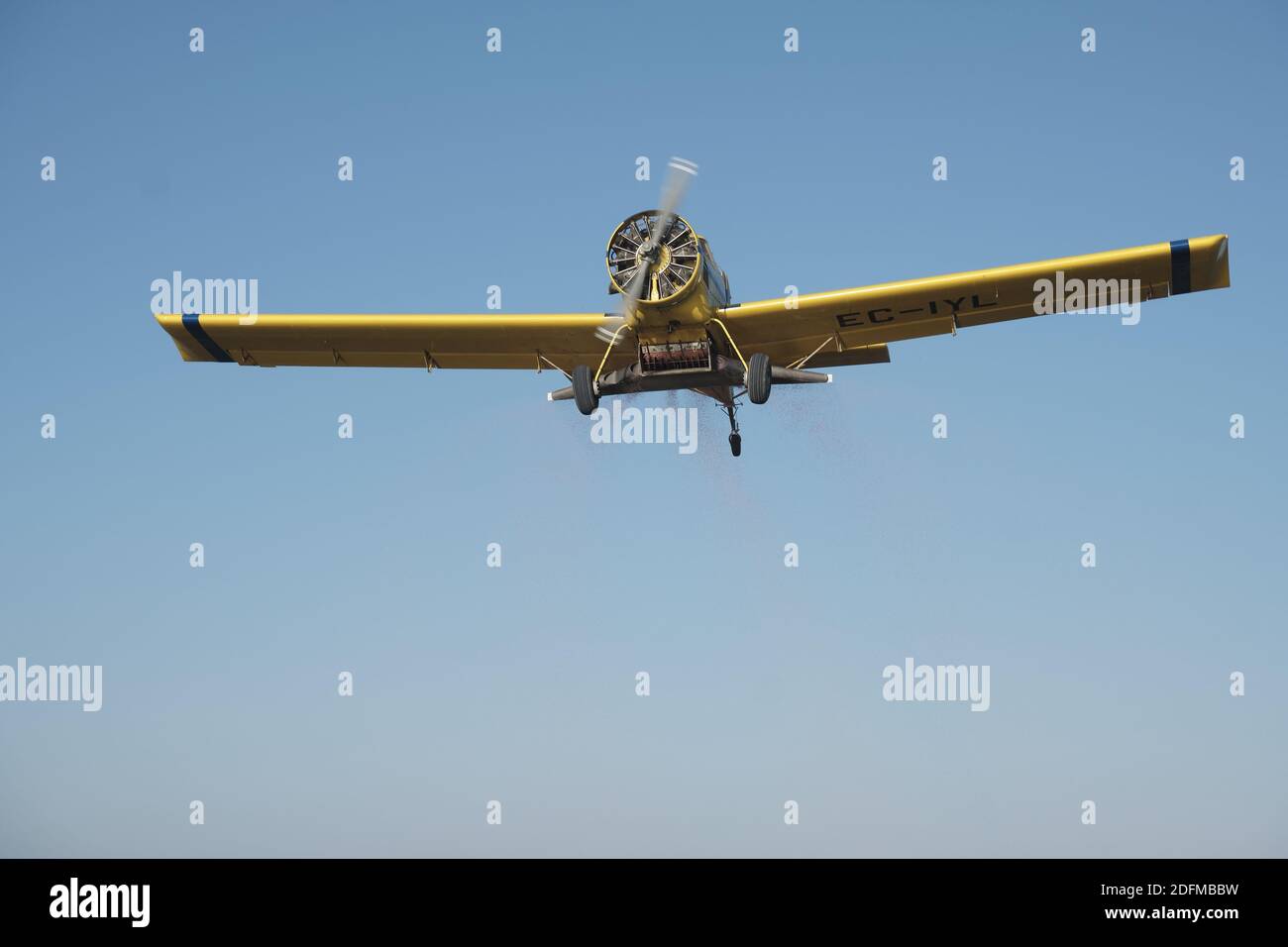 A single-engine propeller airplane flying in a perfectly clear blue sky ...