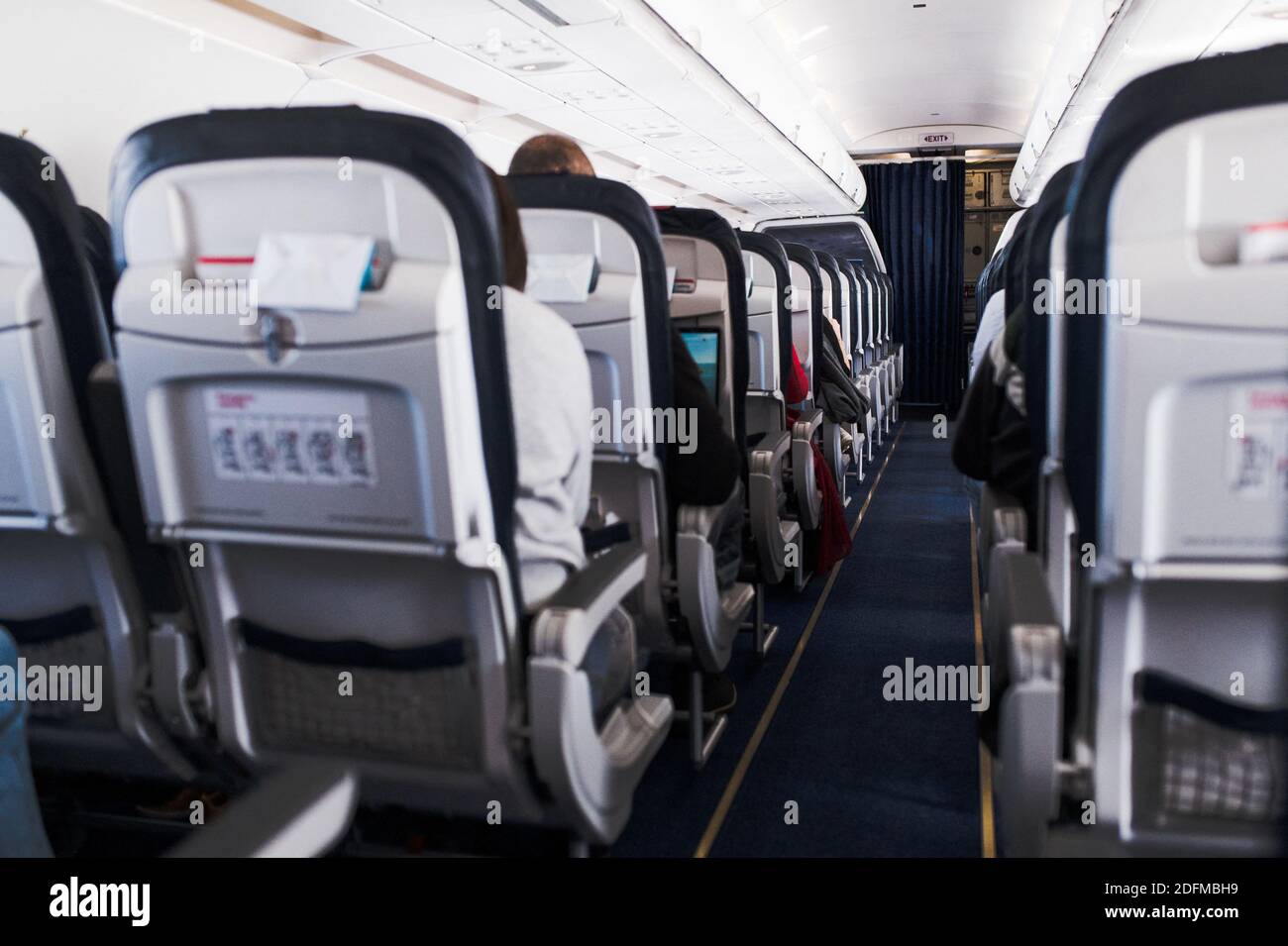 Passengers sleep wearing a face mask in a plane which took off from the ...