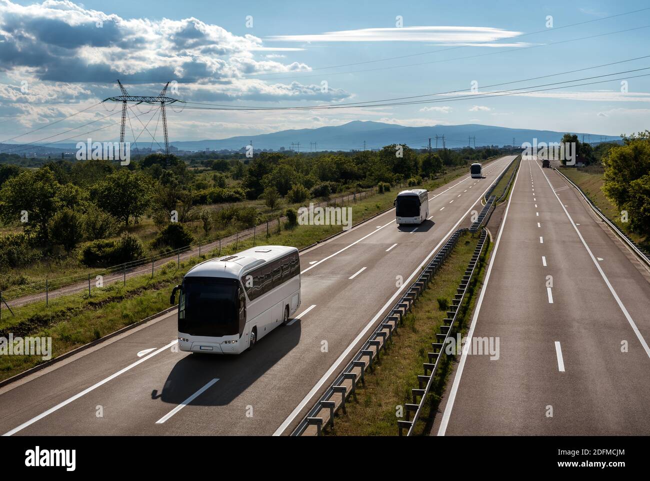 Three White Modern comfortable tourist buses in line driving through ...