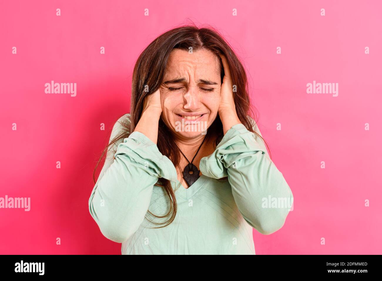 Portrait in studio background of a young scared woman posing with long ...