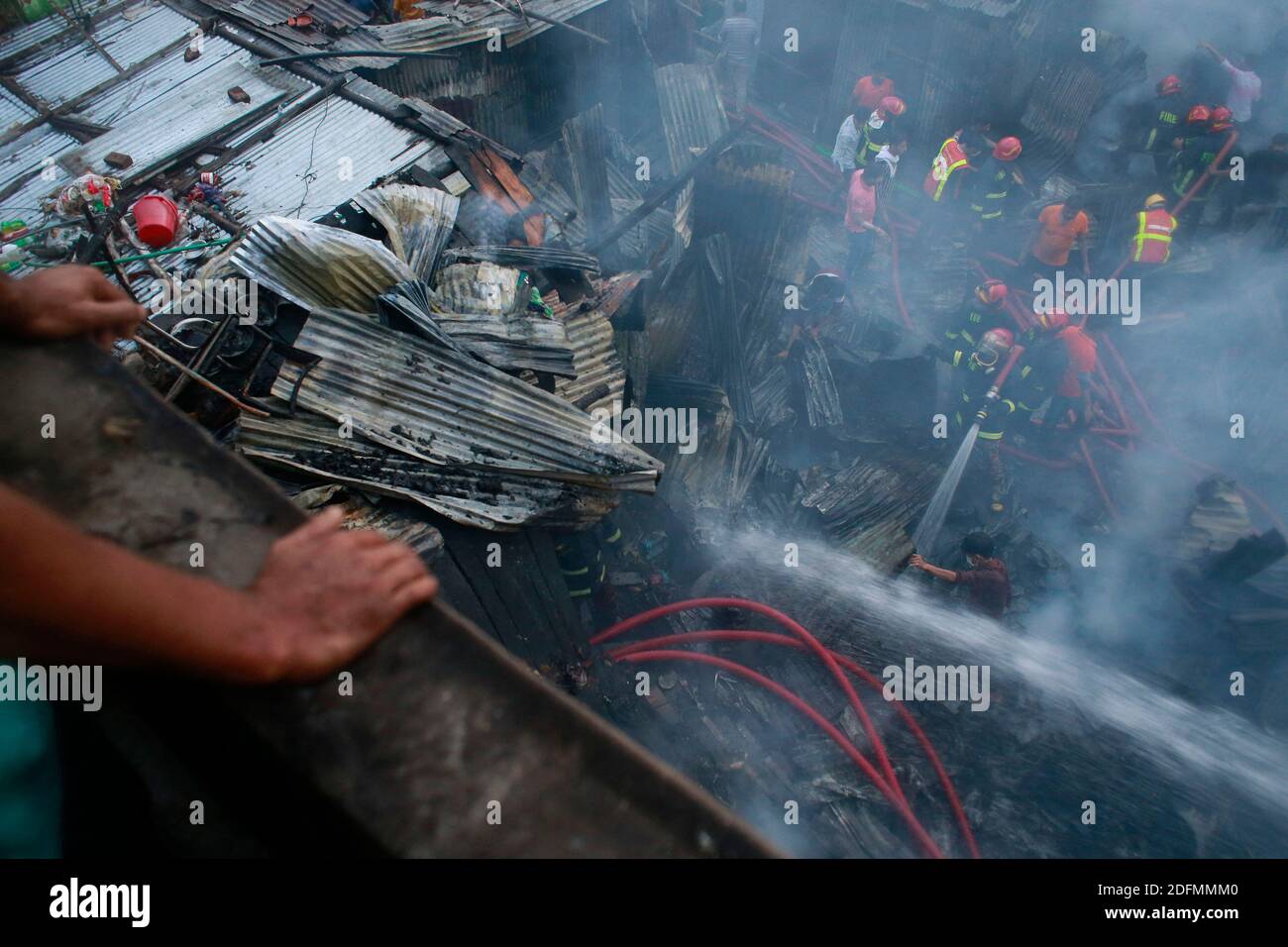 Bangladeshi fire fighters try to douse the fire after flames erupted at ...