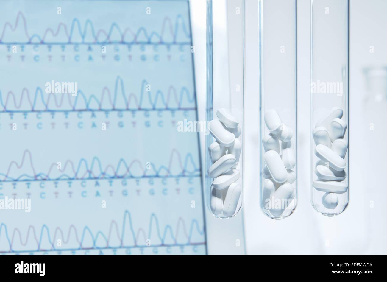 Genetics research. Pills in test tubes in front of the screen of a ...