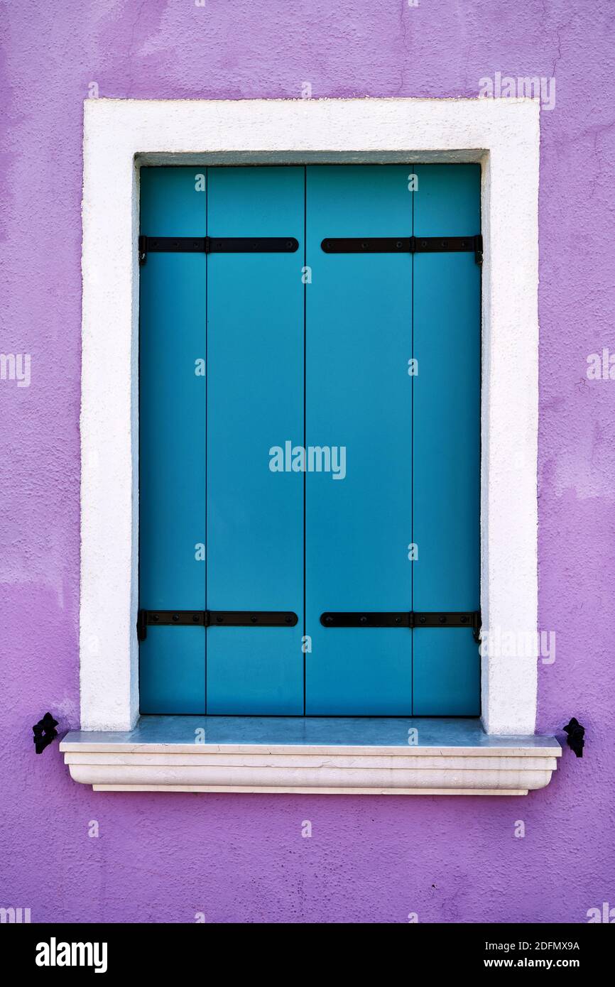 Window with bright blue shutters on the lilac wall. Italy, Venice ...