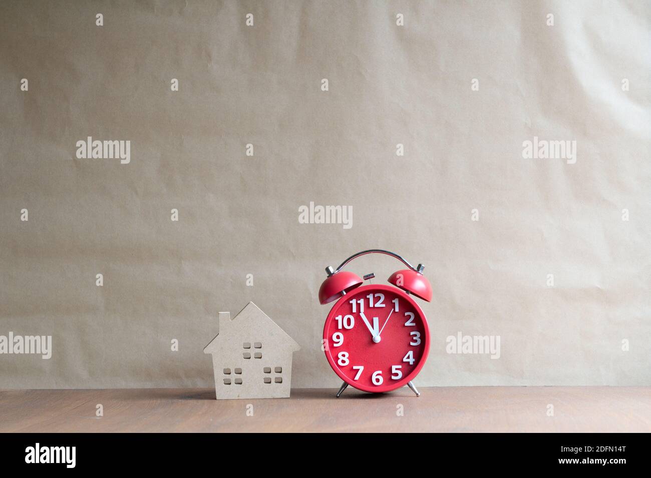Miniature wooden house and black clock,Dream house,Real estate concept ...
