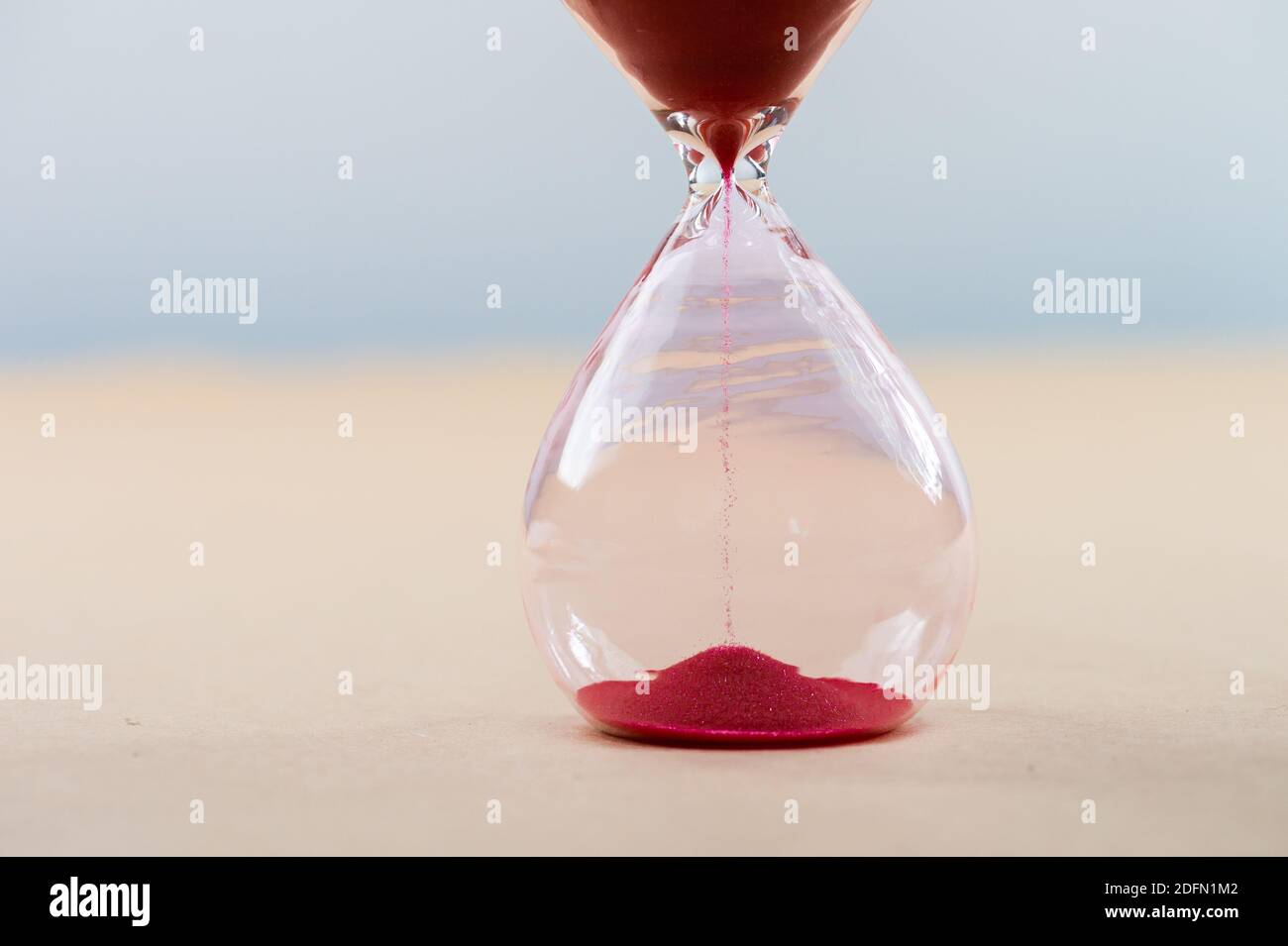 Hourglass with flowing sand on table. Time management Stock Photo - Alamy