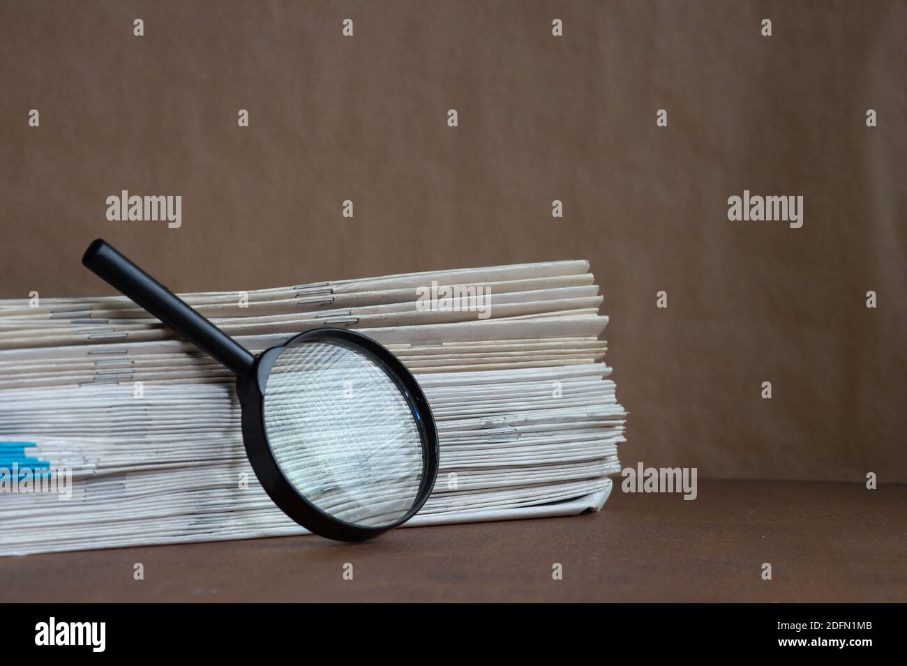 Magnifying glass with stack of documents - concept for searching for a ...
