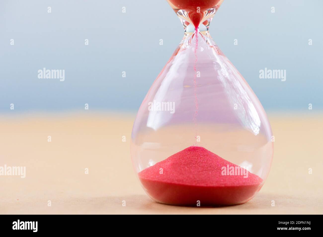 Hourglass red flowing sand hi-res stock photography and images - Alamy