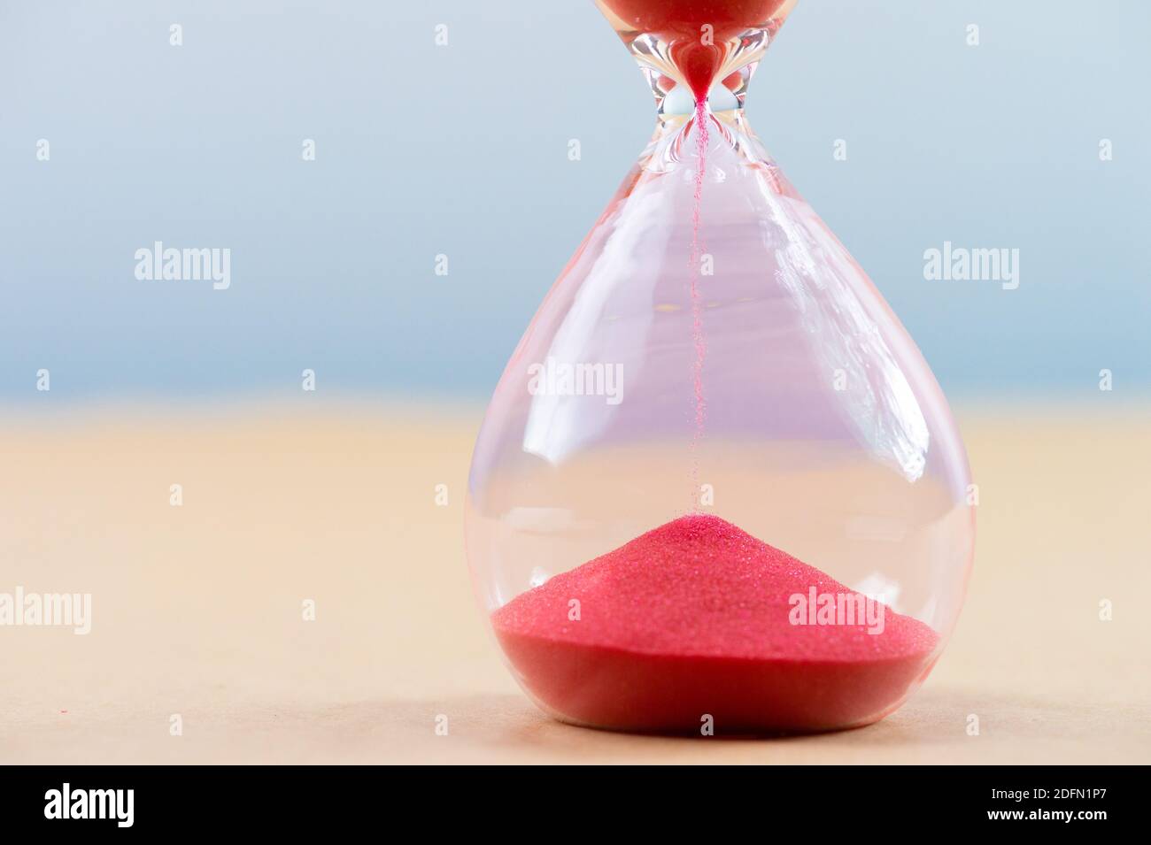 Hourglass red flowing sand hi-res stock photography and images - Alamy
