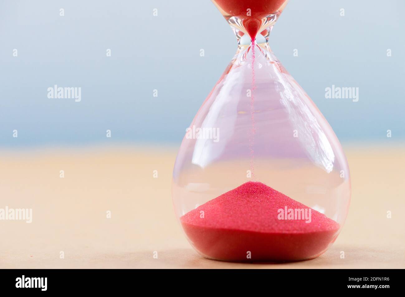 Hourglass with flowing sand on table. Time management Stock Photo - Alamy