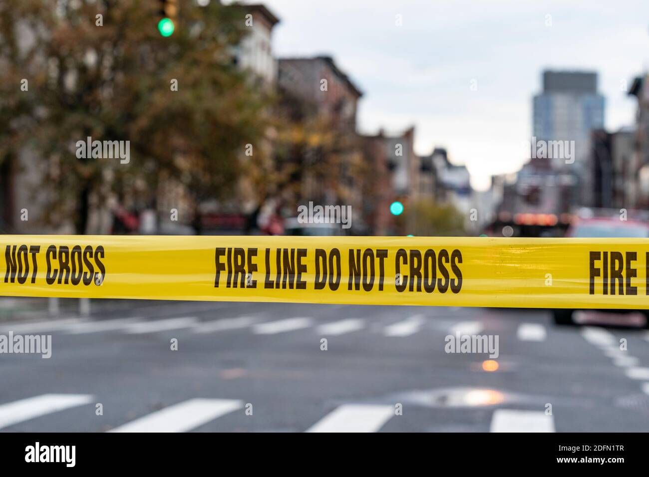 Firefighters install warning tape around fire scene in the city Stock ...