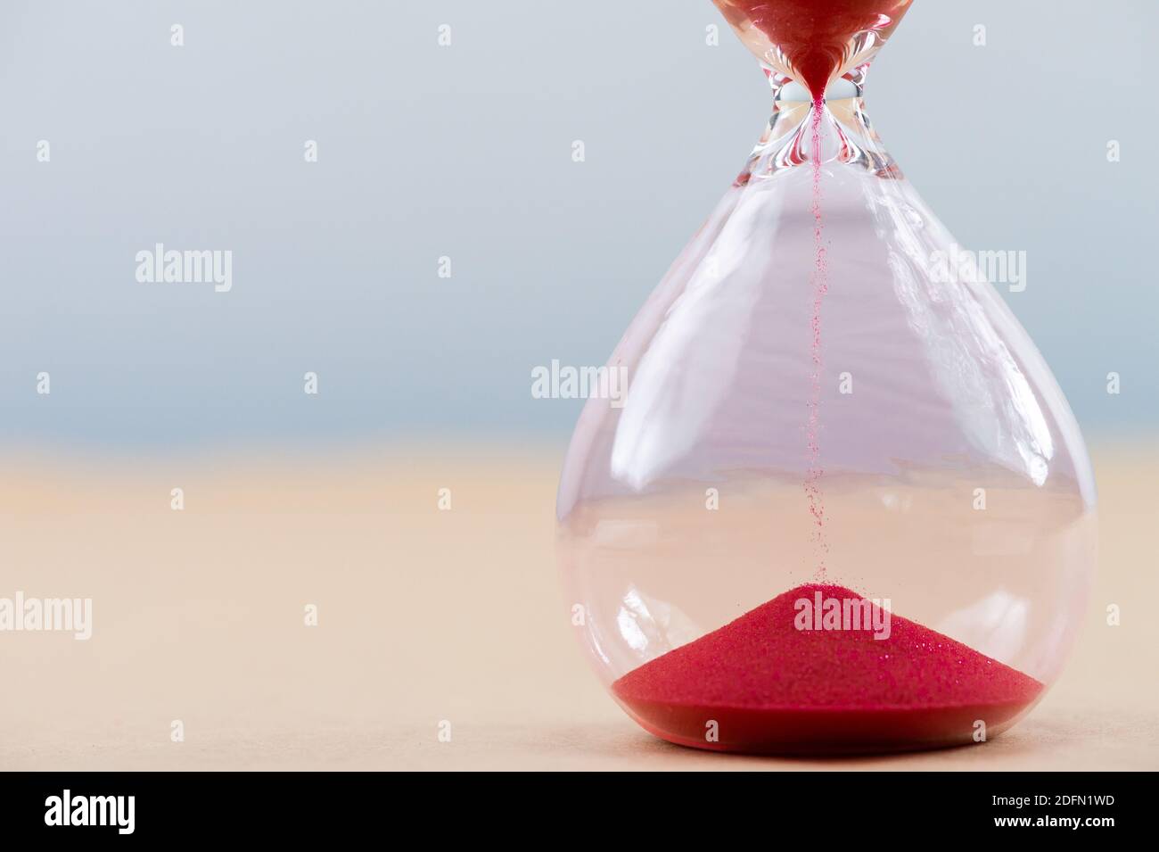 Hourglass with flowing sand on table. Time management Stock Photo - Alamy