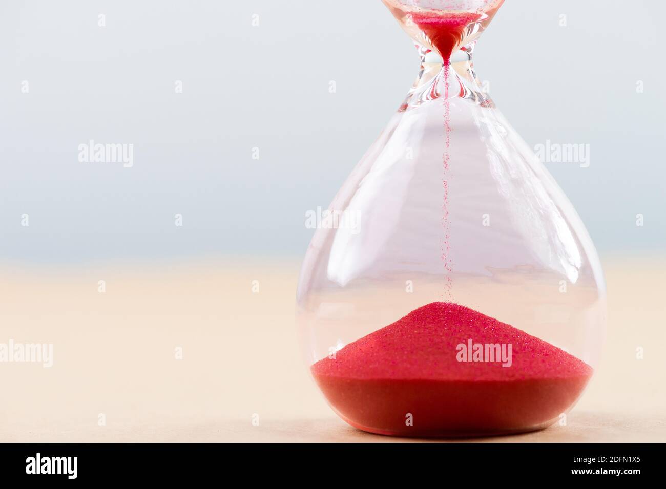 Hourglass with flowing sand on table. Time management Stock Photo - Alamy
