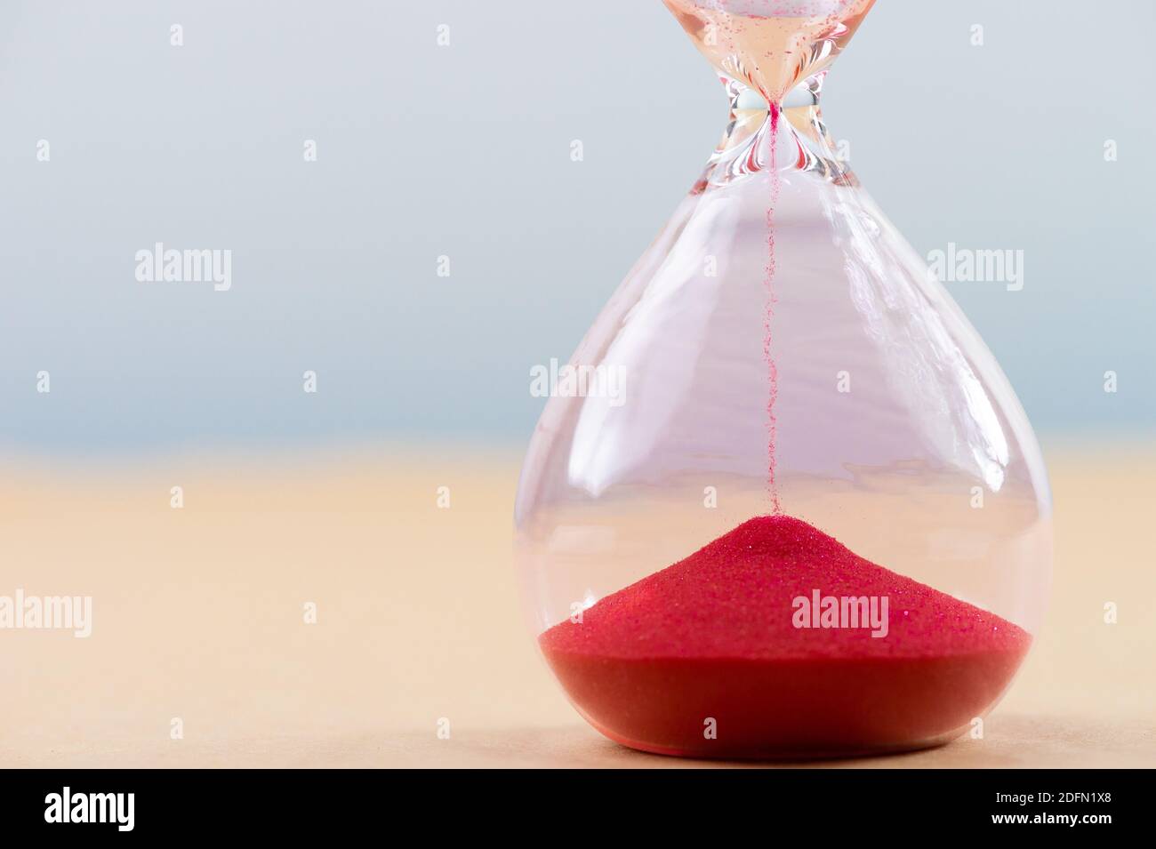 Hourglass with flowing sand on table. Time management Stock Photo - Alamy