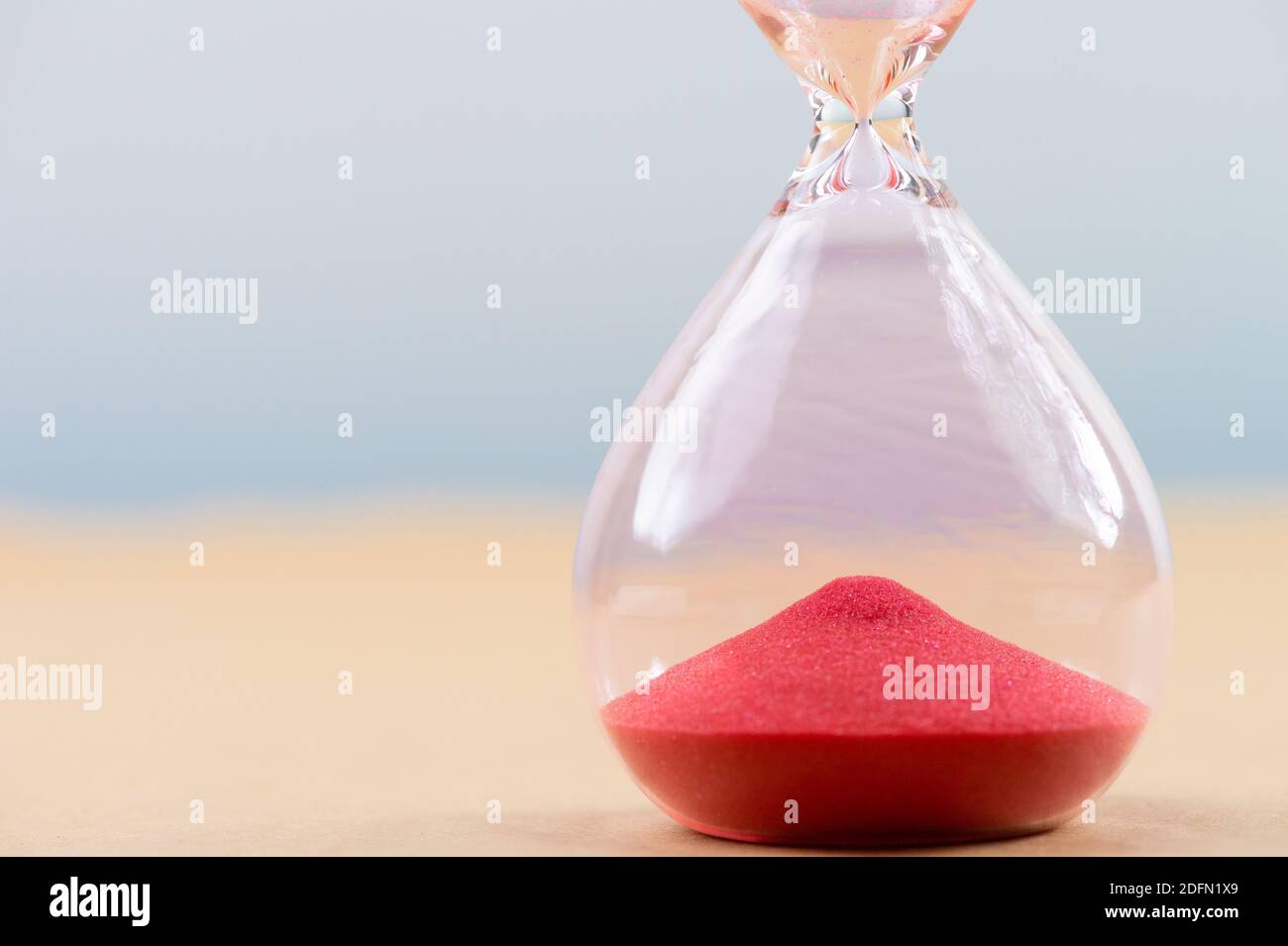 Hourglass with flowing sand on table. Time management Stock Photo - Alamy