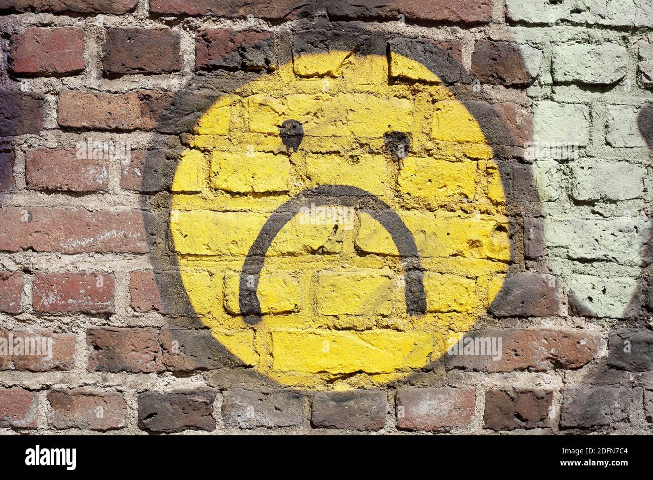 Yellow sad smiley painted on a brick wall, Germany Stock Photo - Alamy