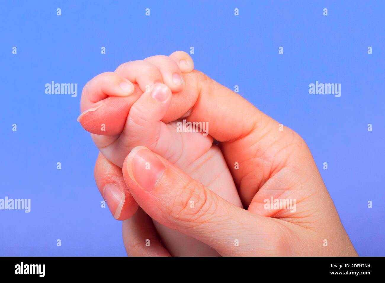 Baby hand grasps adult finger Stock Photo - Alamy