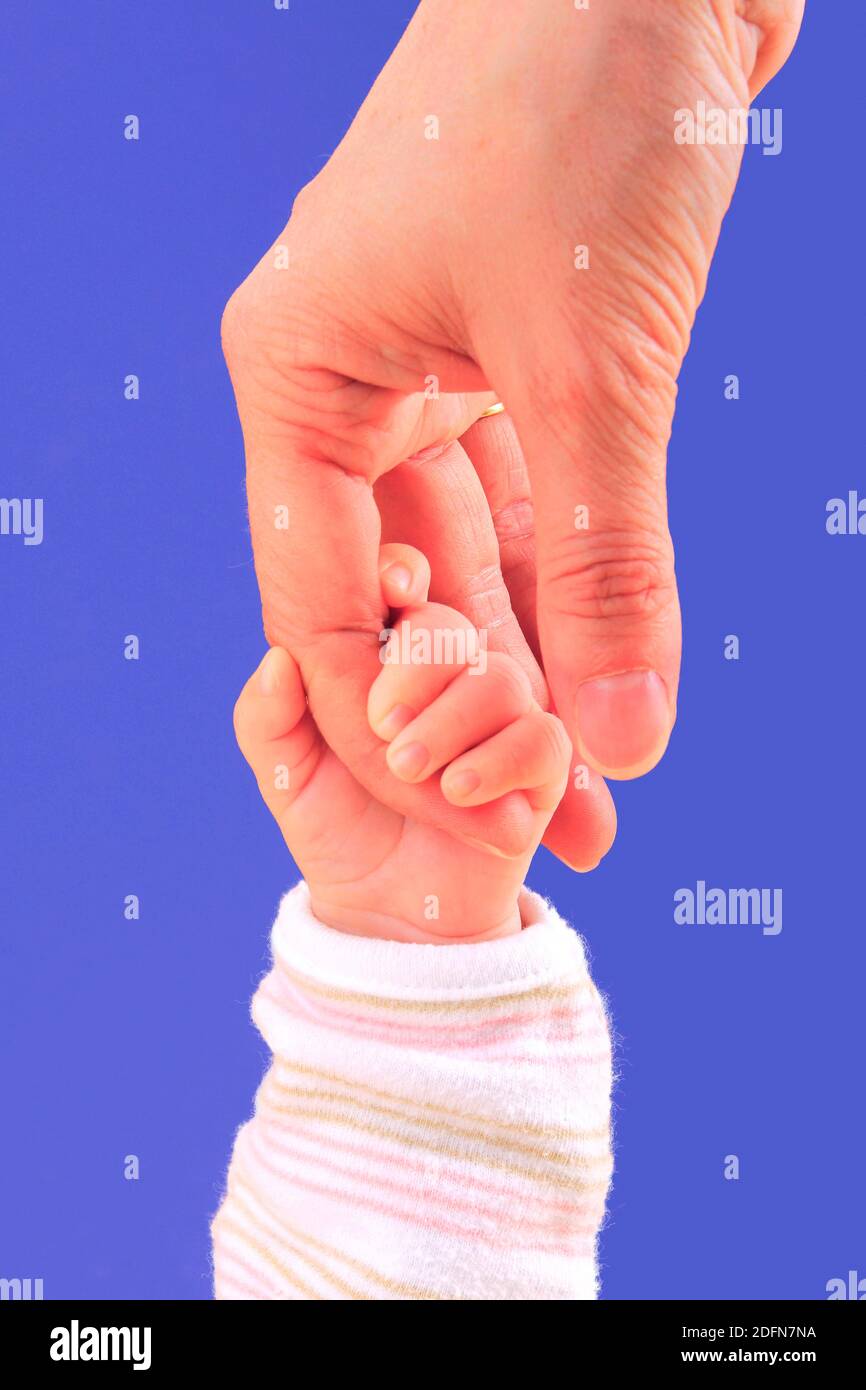 Baby hand grasps adult finger Stock Photo - Alamy