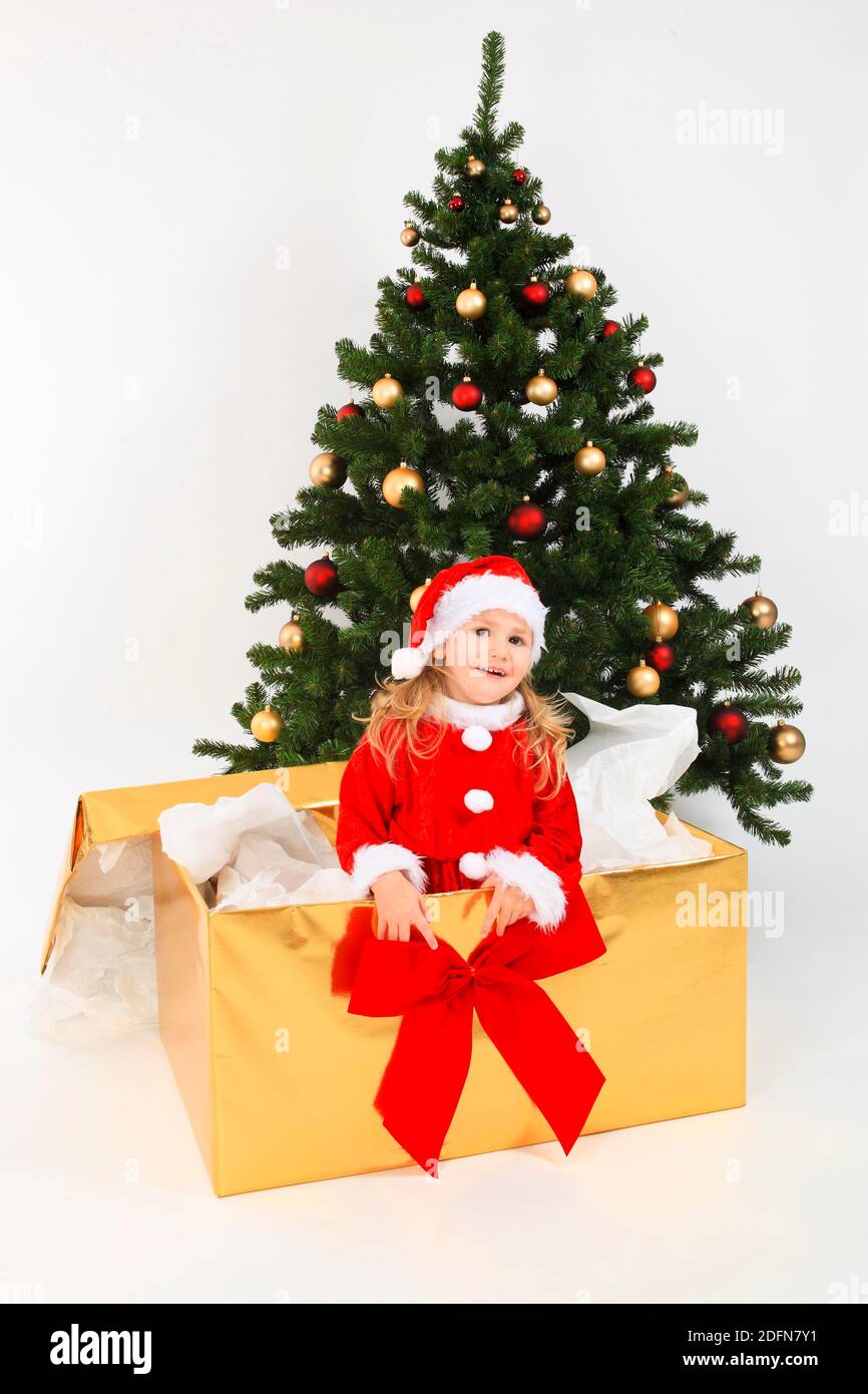 Girl in Christmas present, box, Christmas tree Stock Photo - Alamy