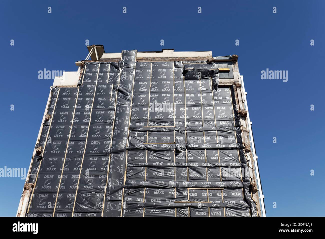 Wrapped, insulated fire protection wall next to a demolished ...