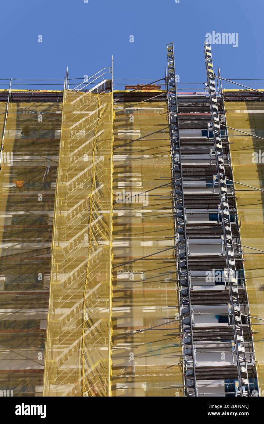 Facade with scaffolding and yellow cladding, building refurbishment ...