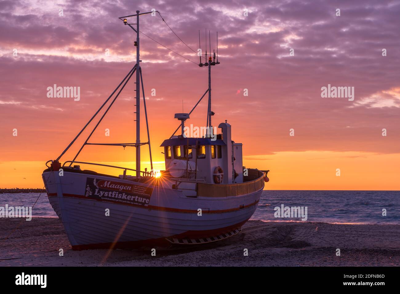 Fishing boat on the beach at sunset, Vorupoer, Nordjylland, Denmark ...