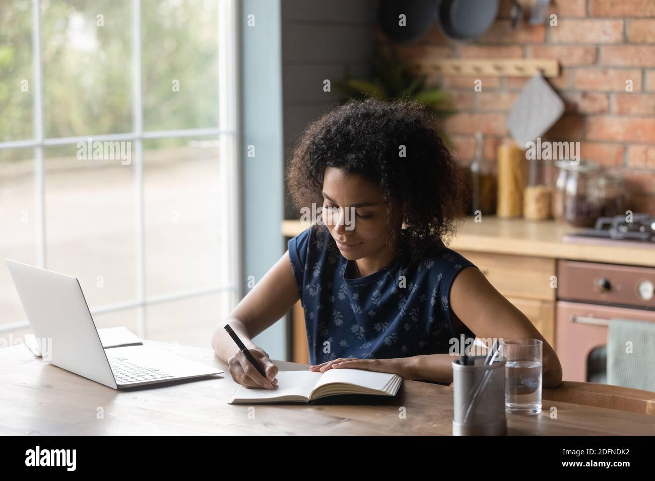Happy millennial biracial lady handwriting in diary Stock Photo - Alamy