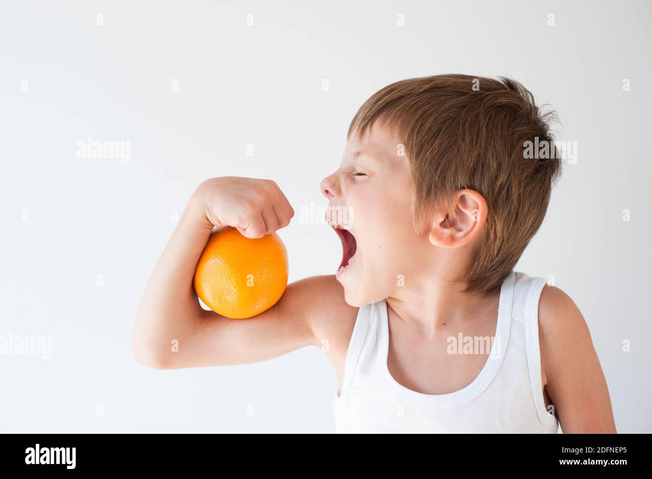 little boy with orange on muscle biceps wishing to bite and eat Stock ...
