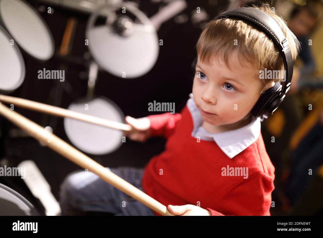 Kid learning to play drums in music class Stock Photo - Alamy