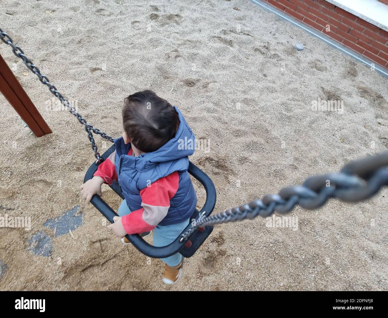 A high angle shot of a cute kid on a swing Stock Photo - Alamy
