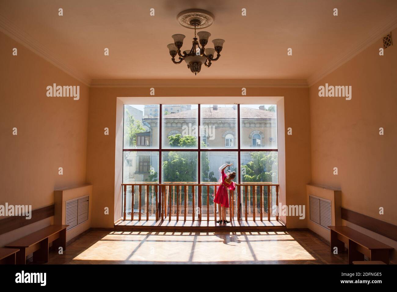 russian ballet school concept of little girl dancing near window in ...