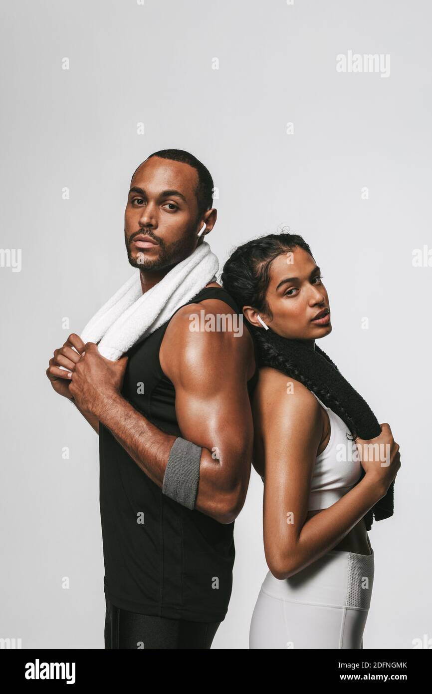 Fit couple standing with back against each other. Fit man and woman ...