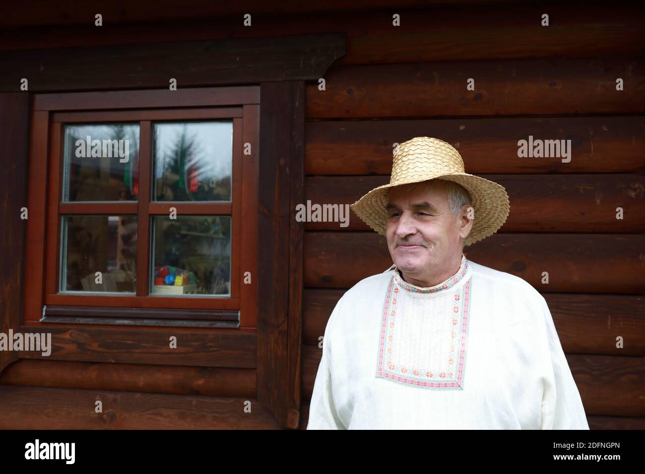 Man in traditional Belarusian clothes on background of log cabin Stock ...
