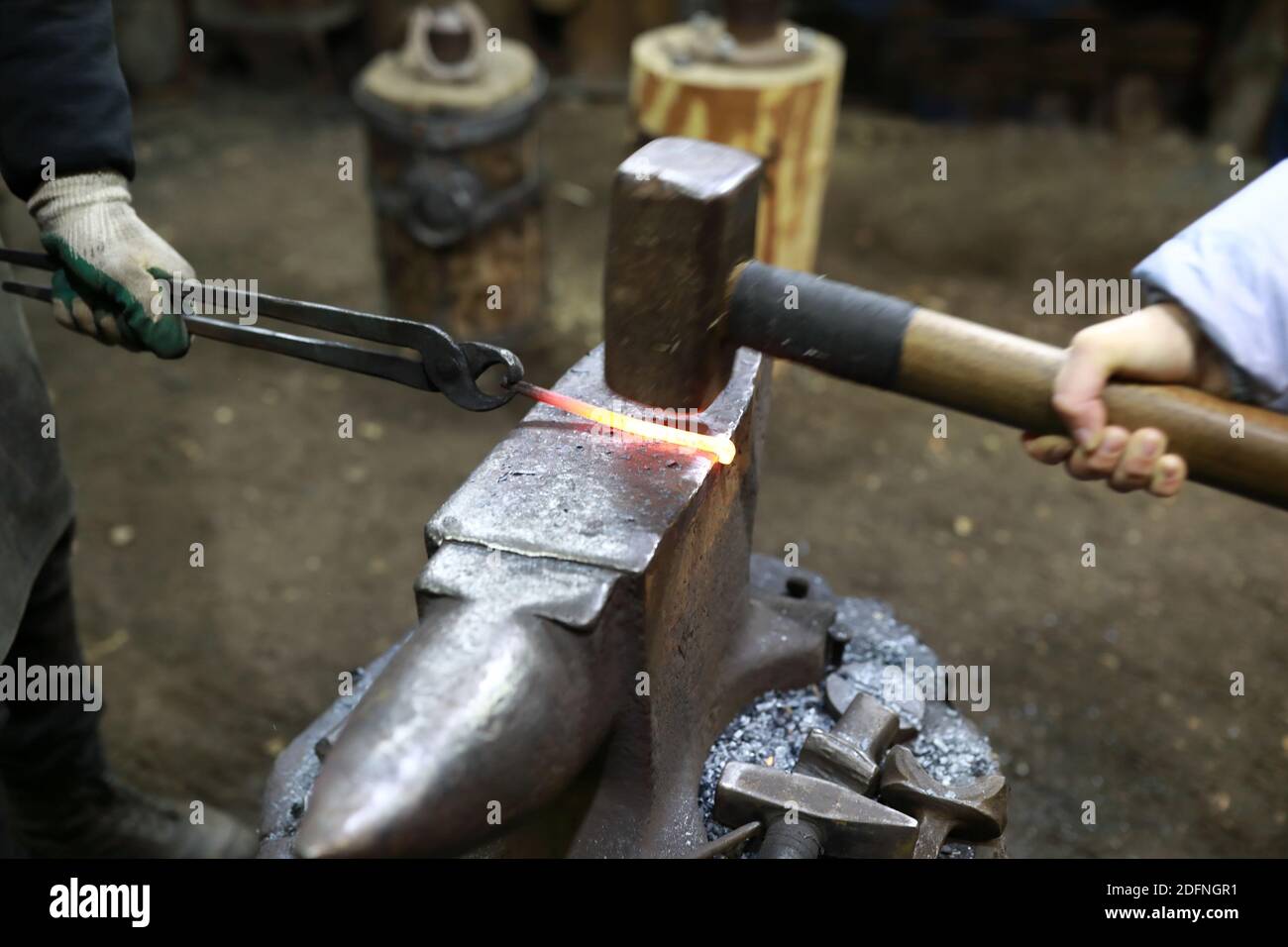 Tourist with blacksmith forges iron at workshop Stock Photo - Alamy