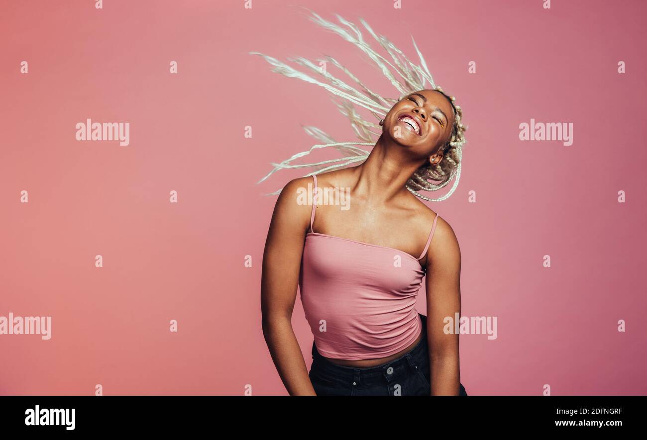 Portrait of smiling woman dancing on pink background. Woman in happy ...