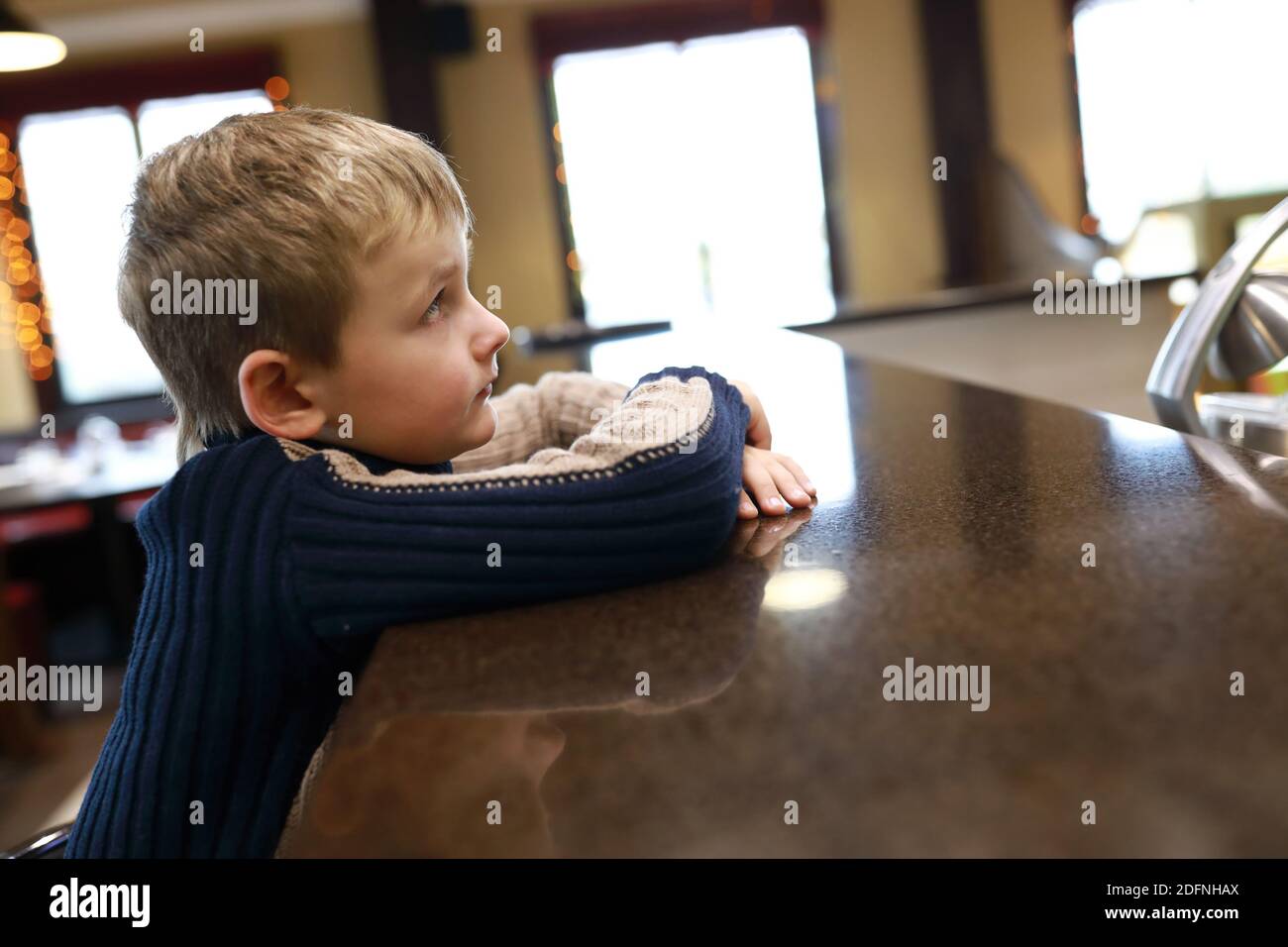 Boy sitting at bar in a restaurant Stock Photo - Alamy