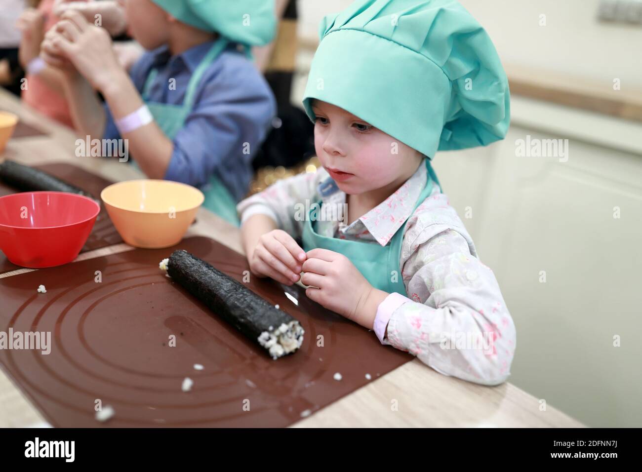 Kid preparing sushi rolls at cooking class Stock Photo - Alamy