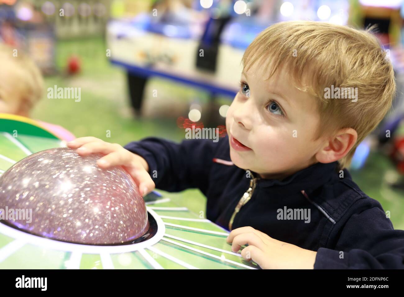 Boy playing arcade game in amusement park Stock Photo - Alamy