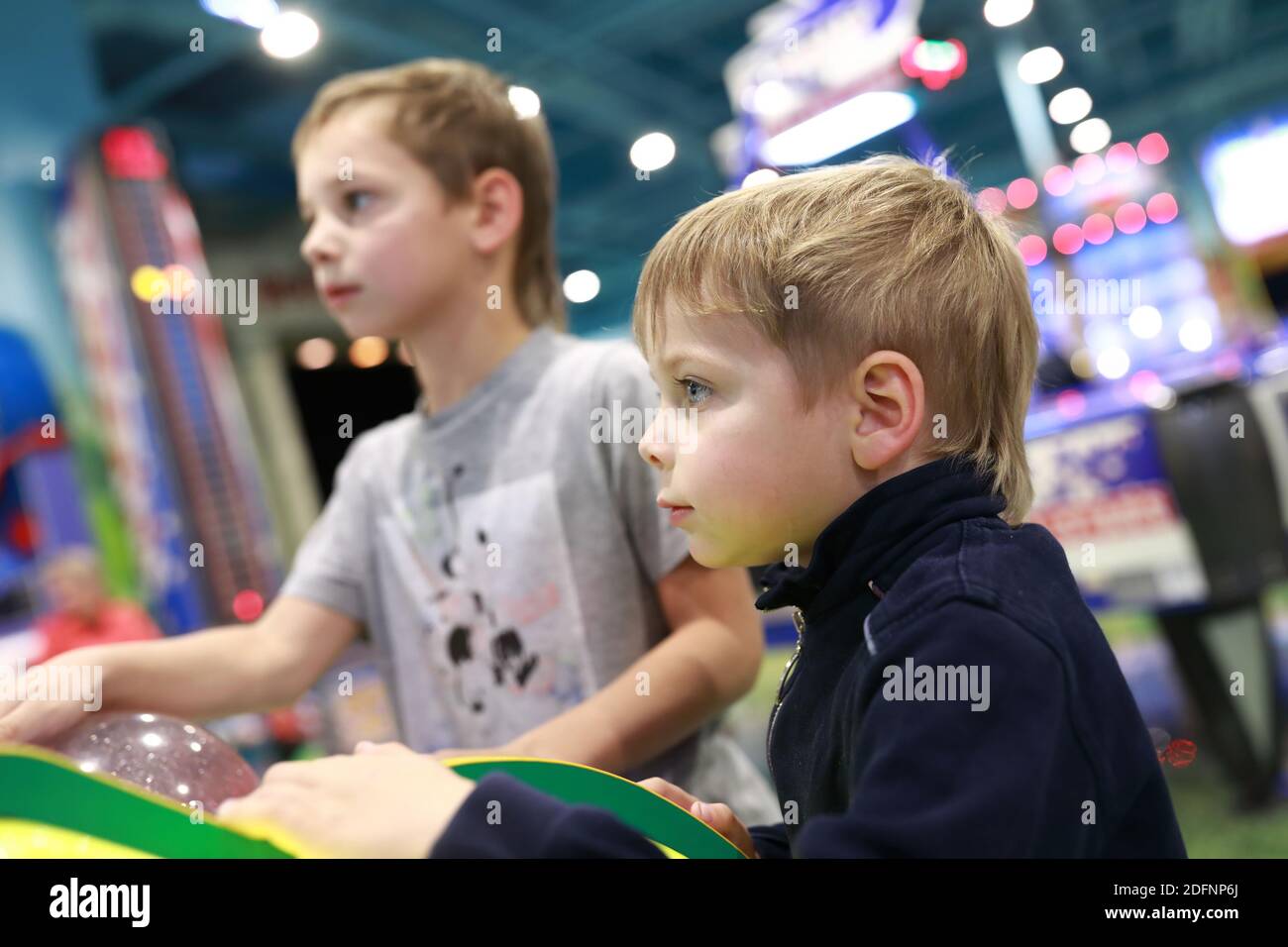 Children playing arcade game in amusement park Stock Photo - Alamy