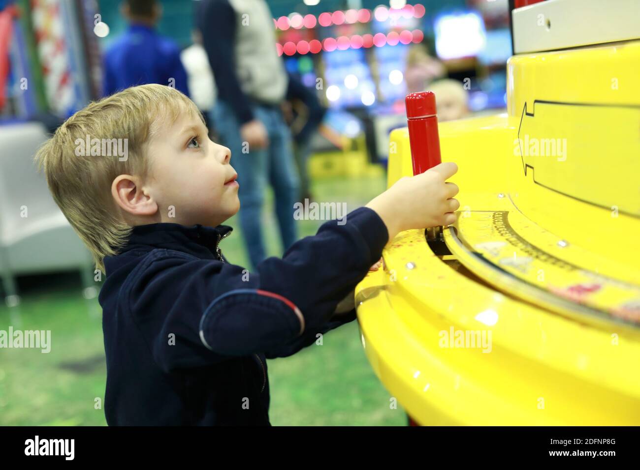 Child playing arcade game in amusement park Stock Photo - Alamy