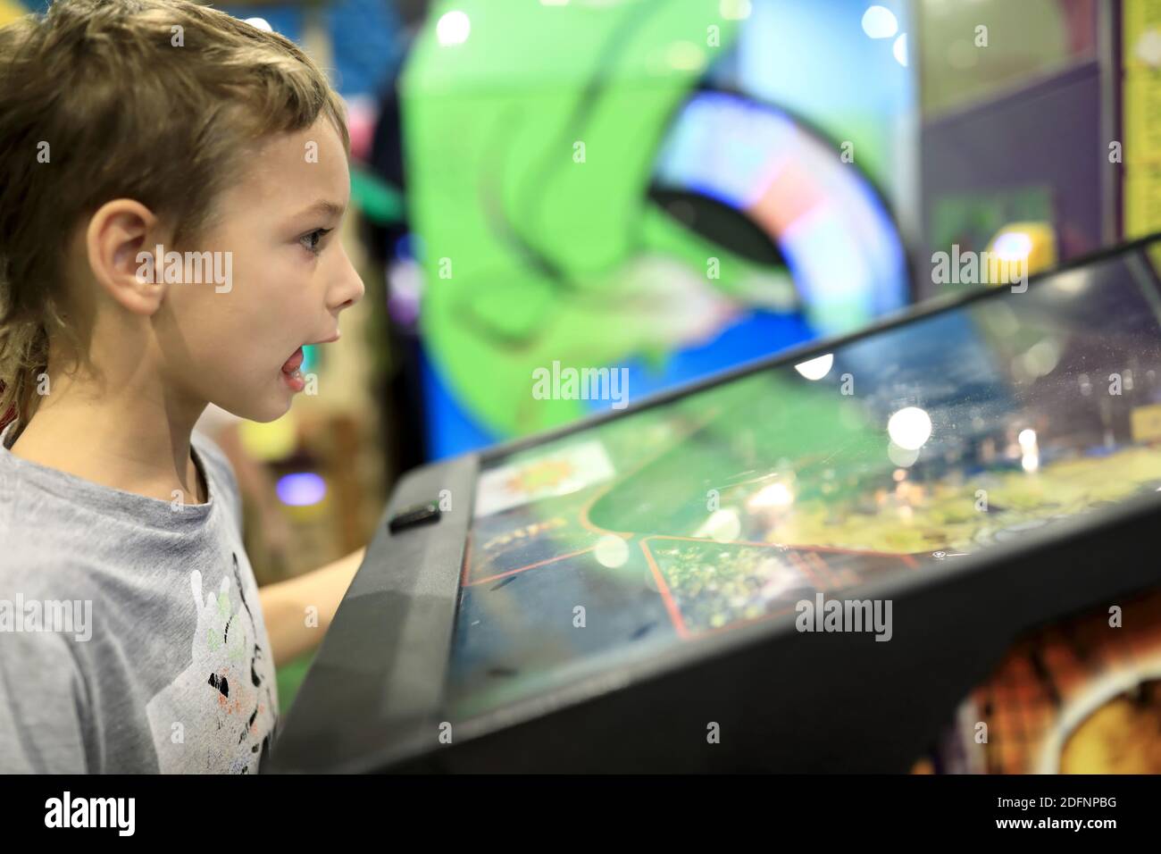 Boy playing arcade game in redemption center Stock Photo - Alamy