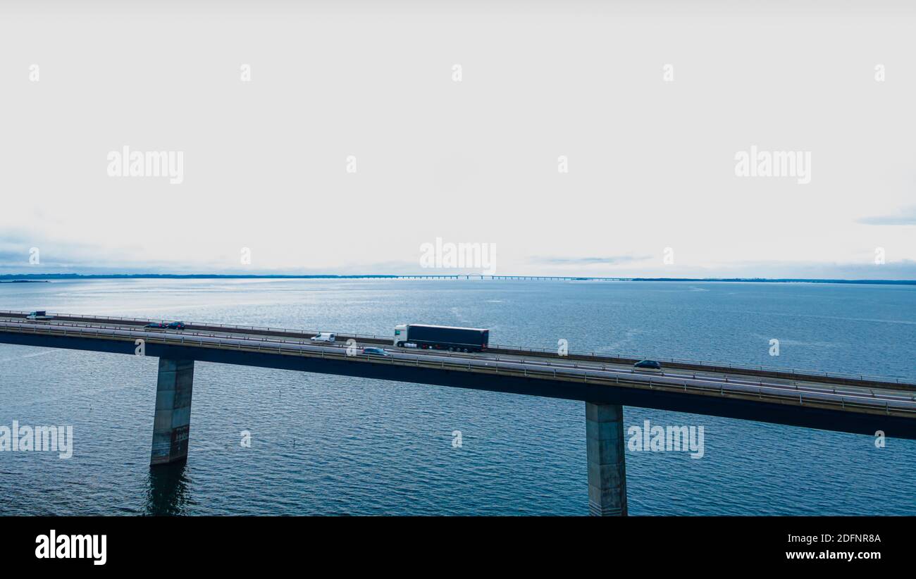 Large highway bridge spanning over a bay, with cars and trucks driving ...