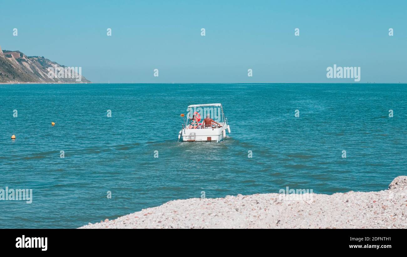 An elderly couple set sail from the port of Pesaro with a white boat ...