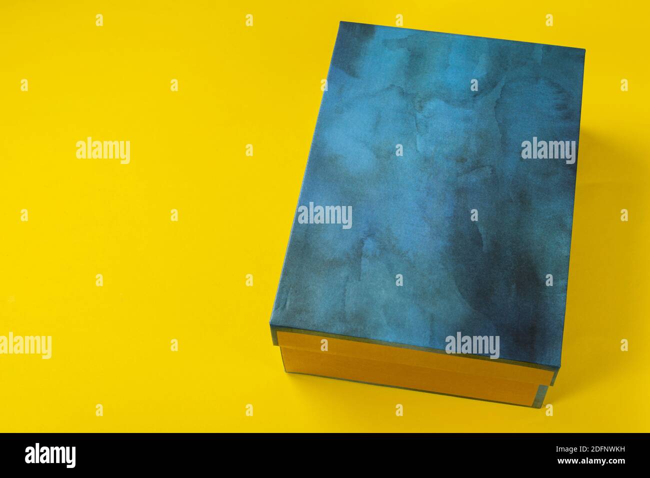 Shoe box in blue on a yellow background. Side view Stock Photo - Alamy