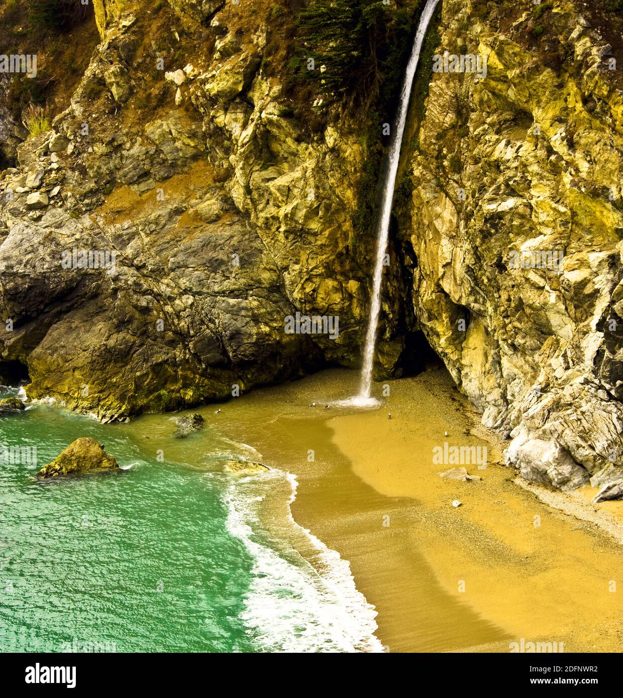 Waterfall dropping on to a beach Stock Photo - Alamy