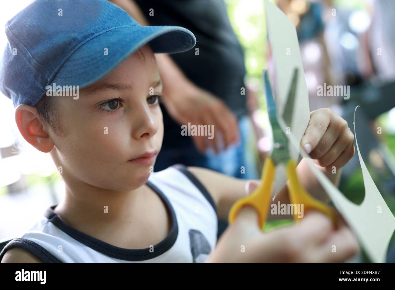 Boy cuts out figure with scissors from sheet of paper Stock Photo - Alamy
