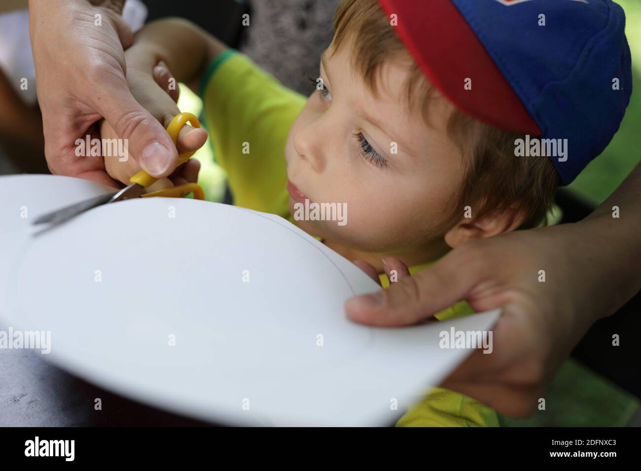 Boy cuts circle from sheet of paper Stock Photo - Alamy