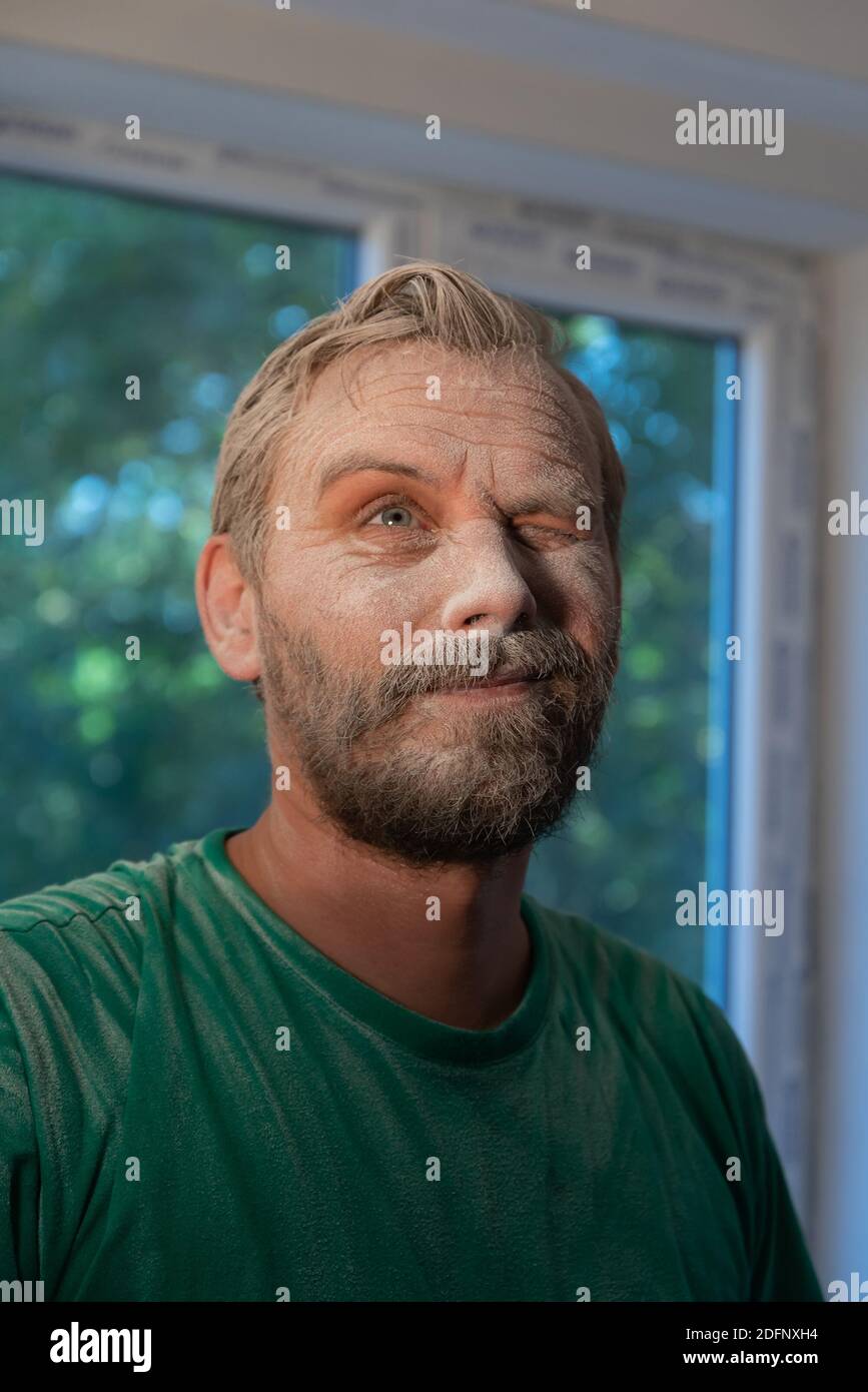 Portrait of man with dust on a face after leveling ceiling inside Stock ...