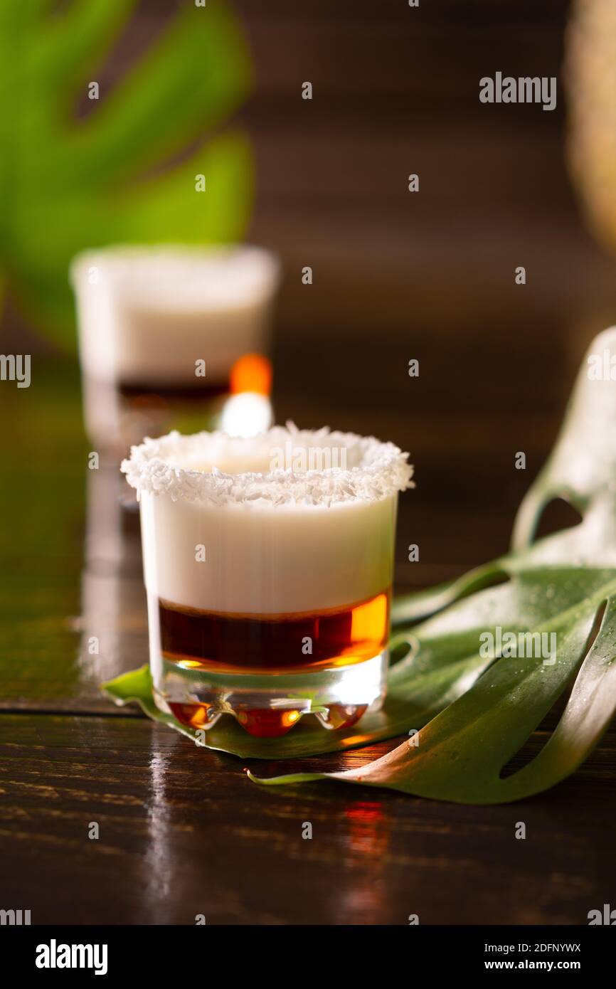 Tropical alcoholic shots decorated with coconut flakes, monstera flower ...