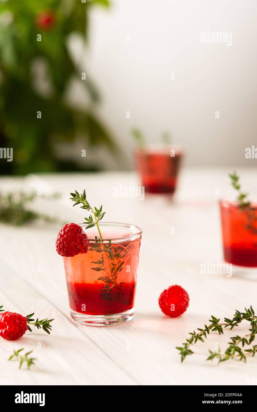 Raspberry alcoholic shots, shot glasses with colored liquor on a white ...